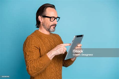 밝은 파란색 배경에 고립 된 안경을 착용 하는 응용 프로그램 태블릿 타이핑을 사용 하 여 진정 자신감 사업가의 사진 초상화