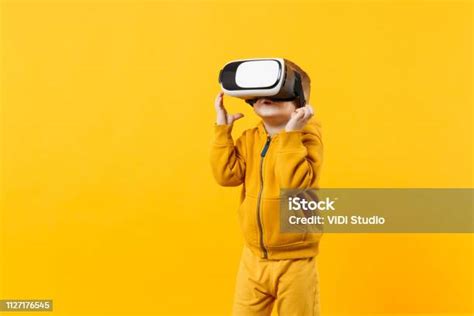 작은 재미 소년 34 세 오렌지 벽 배경 어린이 스튜디오 초상화에 고립 된 눈에 노란 옷과 Vr의 헤드셋을 착용 아이 사람 어린