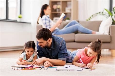 Padre con hijas pequeñas dibujando en casa Foto Premium