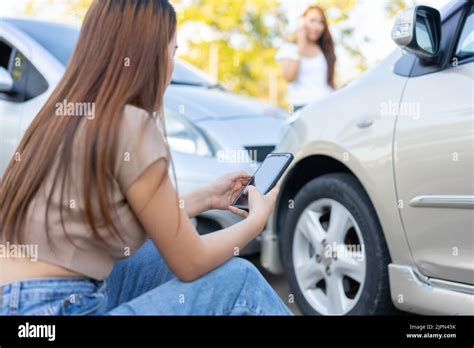 Two Drivers Check For Damage After A Car Accident Before Taking