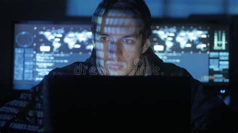 Male Hacker Programmer Working At Computer While Blue Code Characters Reflect On His Face In