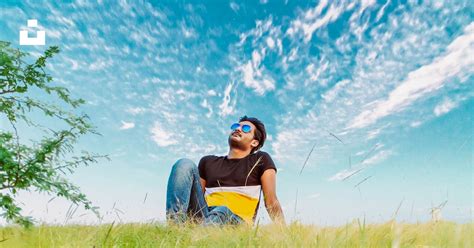 검은 탱크 탑과 파란색 데님 청바지를 입은 여자가 노란색 의자에 앉아 검은 선글라스를 쓰고 있다 사진 Unsplash의 무료 초상 이미지