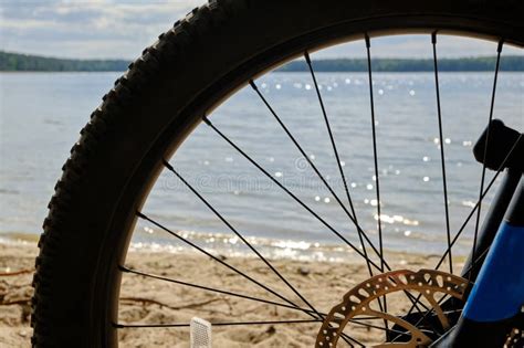 Through The Spokes Of A Large Bicycle Wheel You Can See A Beautiful