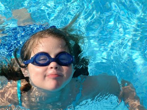 Littlegirlwearingswimgogglesinswimmingpool Премиум Фото