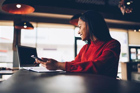 커피 숍에서 무료 와이파이 연결을 사용하여 숙제 프로젝트를 준비하는 온라인 연구를 만드는 쾌활한 아프로 미국 힙스터 소녀 계획을