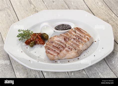 Grilled Pork Steak With Pepper Sauce Served Dried Tomatoes And Thyme
