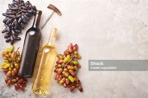 카피 공간이있는 오래된 회색 콘크리트 테이블 배경에 포도와 와인 잔이있는 와인 병 2 개 포도 나무 가지와 레드 와인 소박한 배경에 와인 구성 모의 0명에 대한 스톡 사진