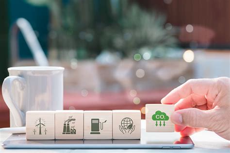 탄소 중립 및 넷 제로 개념 탄소 배출 감소 재생 가능 에너지 쓰레기 재활용 및 녹색 생산을 위한 Netzero 기호가 새겨진 나무 큐브를 손으로 놓습니다 0명에 대한 스톡