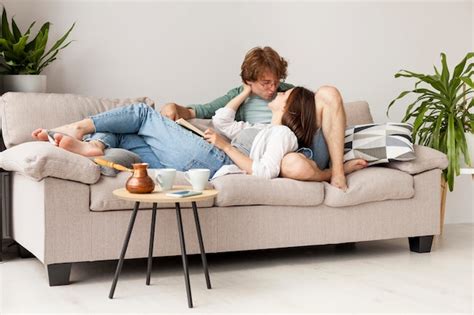 Couple Plein Coup Assis Sur Le Canapé Photo Gratuite