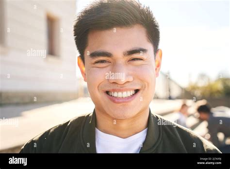 Outdoor Portrait Of A Smiling Chinese Guy Looking At The Camera Laughing With Positive Face And