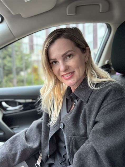 Stylish And Expressive Blonde Woman Sitting In Modern Car And Looking