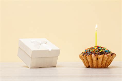 베이지 색 배경에 불타는 축제 촛불과 선물 상자와 맛있는 생일 머핀 기념일에 대한 스톡 사진 및 기타 이미지 기념일 머핀
