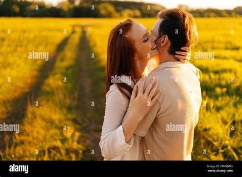 Smiling Redhead Young Woman With Closed Eyes And Unrecognizable Man In
