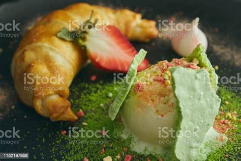 머 랭과 딸기로 장식 된 나무 블랙 테이블에 검은 접시에 바닐라 아이스크림의 특 종을 가진 사과 슈트 루 델 슬라이스 클로즈업 구운 디저트의 수평 보기 0명에 대한 스톡