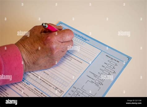 Lady With Pen Filling In DVLA Form On Desk In Uk Stock Photo Alamy