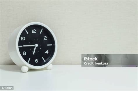 근접 촬영 흑인과 백인에 대 한 알람 시계 장식 7 또는 흰색 나무 책상과 크림 벽지 질감 배경 복사 공간에 오전 6 시 45