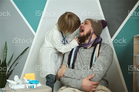 아버지와 아이 놀이 클리닉과 의사 청진기와 의료 가운에 어린 소년 치과 의사 치료 아빠 2명에 대한 스톡 사진 및 기타 이미지