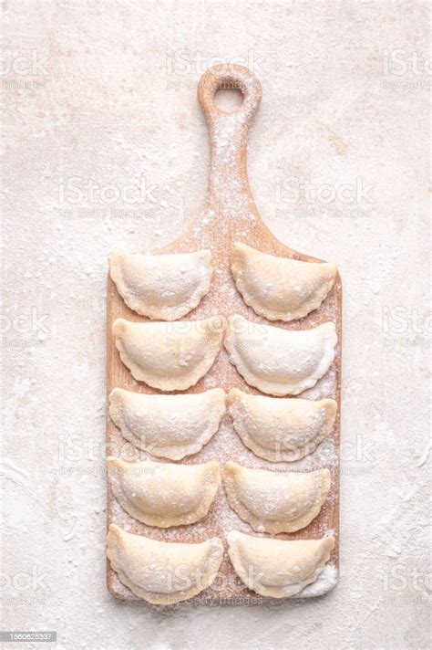 감자와 원시 만두 나무 판에 밝은 배경에 만두를 준비합니다 신선한 수제 우크라이나 만두 국가 전통 마스나 수제 반죽 제품 공예