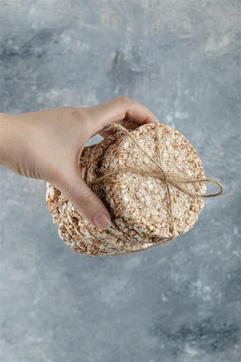 Female Handholding Stack Of Rice Cakes On Marble Background Stock Image