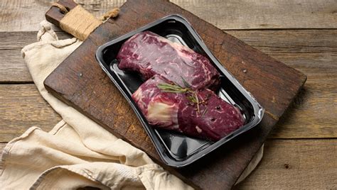 향신료가 있는 플라스틱 용기에 두 개의 생 소고기 스테이크가 있으며 나무 배경에서 진공 청소기로 청소 음식에 대한 스톡 사진 및 기타 이미지 Istock