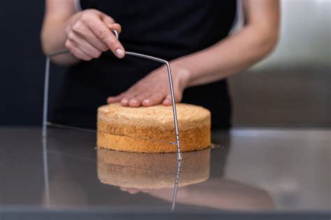 검은 앞치마를 입은 전문 과자 장수가 끈 칼로 케이크를 자르는 데 손을 얹고 있다 검은색에 대한 스톡 사진 및 기타 이미지 검은색 다이어트 달콤한 음식 Istock