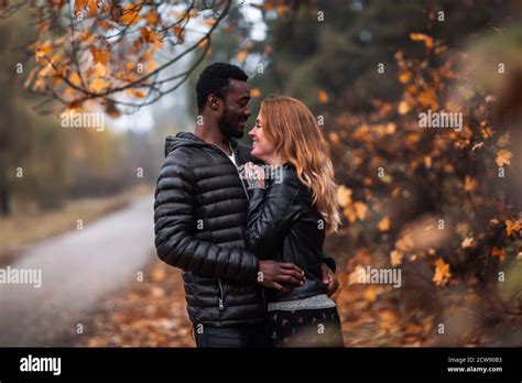 Happy Cute Interracial Couple Posing In Blurry Autumn Park Background
