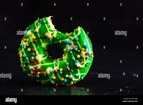 Green Glazed Donut With Sprinkles Isolated Close Up Of Colorful Bitten