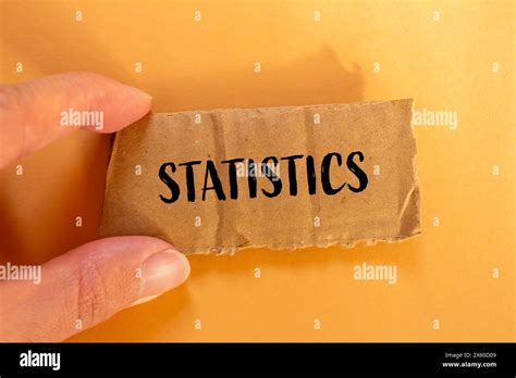 Statistics Word Written On Ripped Cardboard Paper Piece With Orange