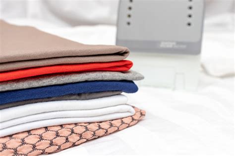 흰색 현대 전기 다리미와 함께 여러 가지 빛깔의 옷의 스택다림 질 세탁 및 가사 개념 가사 집안일에 대한 스톡 사진 및 기타