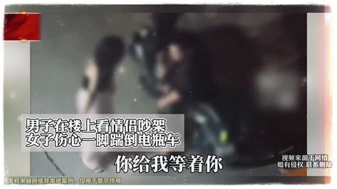 男子在楼上看情侣吵架，女子伤心一脚踹倒电瓶车