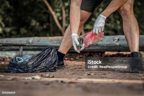 공공 공원에서 쓰레기와 플라스틱 쓰레기를 줍는 남자 자원 봉사자 장갑을 끼고 쓰레기를 검은 색 비닐 봉지에 실외로 넣는 청년 따기에 대한 스톡 사진 및 기타 이미지 Istock