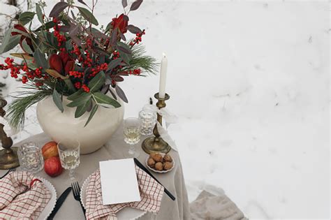 크리스마스 축제 야외 테이블 설정 새해 저녁 식사 와인 한 잔 홀리 아마릴리스 소나무 유칼립투스 꽃병 겨울 결혼식 발렌타인 데이 빈 메뉴 카드 모형입니다 흐릿한 눈 배경