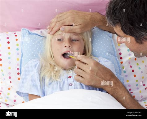 Father Checking His Daughter S Temperature With A Thermometer Stock Photo Alamy