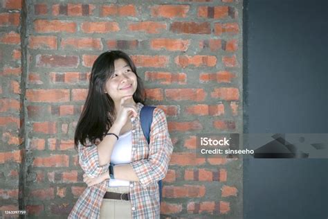 벽돌 배경으로 포즈를 취하는 예쁜 어린 중국 소녀 공간을 복사합니다 귀여운에 대한 스톡 사진 및 기타 이미지 귀여운 긴 머리 대학교 Istock
