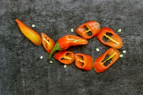 밝은 붉은 색과 오렌지색 칠리 고추 어두운 돌 배경에 반지로 썬 개념핫 뉴스 향신료 조리법 조미료 가을에 대한 스톡 사진 및