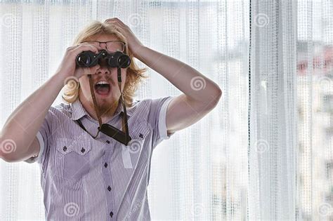Hombre Con Prismáticos Espiando A Los Vecinos Imagen De Archivo