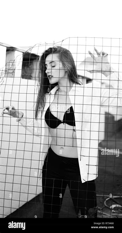 A Girl Behind A Grid In A Park Posing In A Day With A Sunlight Stock