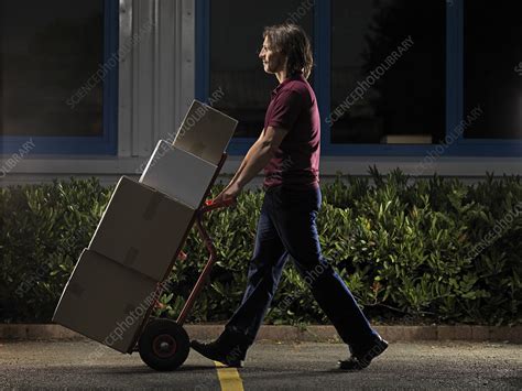 Man Moving Boxes At Night Stock Image F003 8785 Science Photo Library