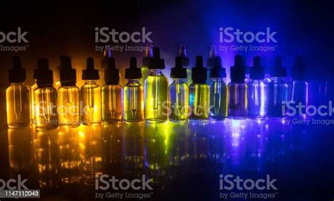 Vape 개념입니다 어두운 배경에 연기 구름과 Vape 액체 병 조명 효과 배경 또는 전자 담배 광고로 유용 합니다 0명에 대한