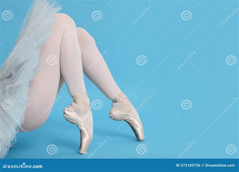 Young Ballerina In Pointe Shoes Practicing Dance Moves On Light Blue