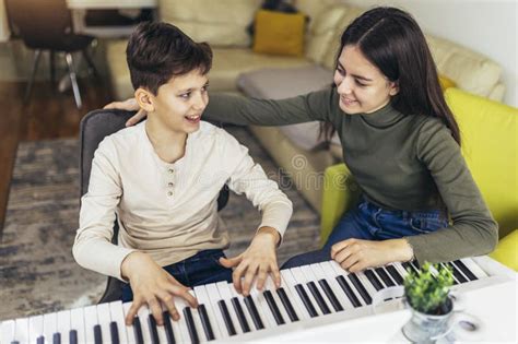Brother And Sister Play Electric Piano At Home And Have Fun Stock Image