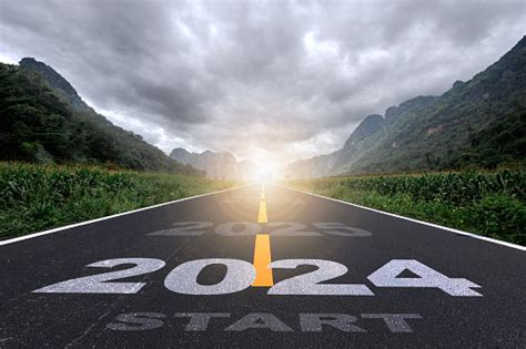2024년 2024년 새해 또는 2024년이라는 단어의 개념의 시작 일몰 산을 배경으로 포장도로 한가운데에 쓰여진 계획