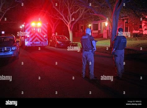 Detroit Police Officers Talk By An Ambulance At Night After Dealing