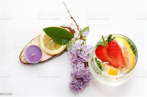 레몬 오이와 딸기와 라일락 나무 장식 흰색 배경에 맛된 물 해독 건강 식품 개념입니다 상쾌한 여름 수 제 칵테일입니다 공간에