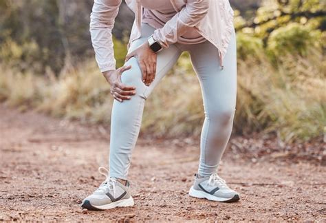Dor no joelho de esportes e mulher no parque após exercício de corrida