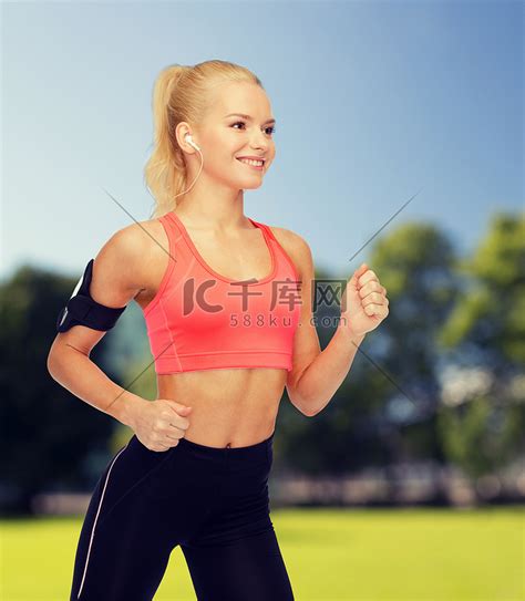 带着智能手机和耳机跑步的运动型女性高清摄影大图 千库网