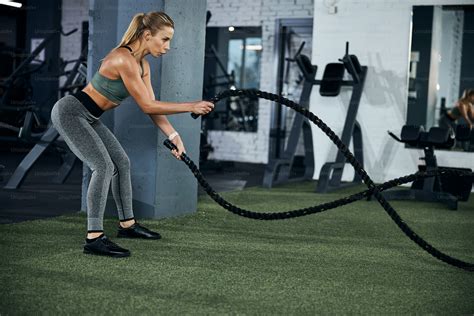 Gym Attendant Bending Ahead And Performing An Exercise With Battling