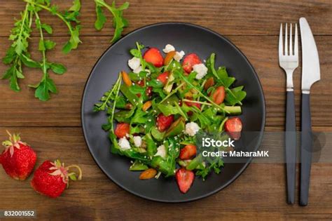 Arugula 딸기 코 티 지 치즈 검은 접시 나무 배경에 올리브 오일 샐러드 클로즈업입니다 상위 뷰 0명에 대한 스톡 사진 및