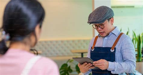 아시아 남성 커피숍 매니저가 일하기 전에 남녀 직원 팀에 브리핑을 하고 있다 소상공인 카페 및 식당 주인은 영업 전에 고객에게 서비스를 준비하는 아르바이트를 지시합니다