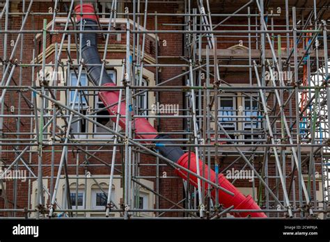 Scaffolding On The Side Of A House With A Refuge Or Rubbish Shoot